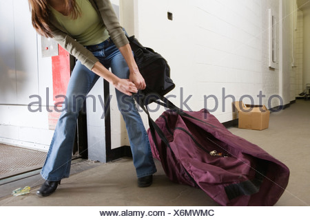 Young traveling woman pulling heavy suitcase on wheels Stock Photo ...
