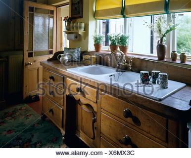 Double white sink below window in modern kitchen with glass shelves ...