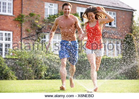 Woman running through sprinkler Stock Photo: 47784888 - Alamy