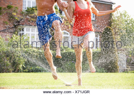Woman running through sprinkler Stock Photo: 47784888 - Alamy