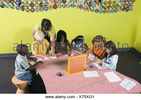 An art teacher observing her students drawing in art class Stock Photo ...