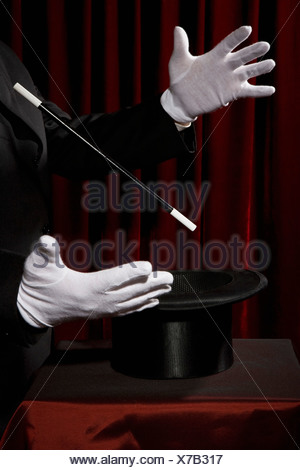 shot of a magicians top hat, gloves and magic wand isolated on a pure ...