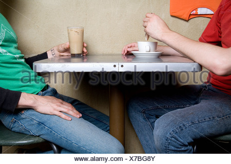 Young people sitting at a cafe table. Group of friends talking in a ...