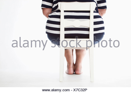Overweight woman on chair, rear view Stock Photo - Alamy