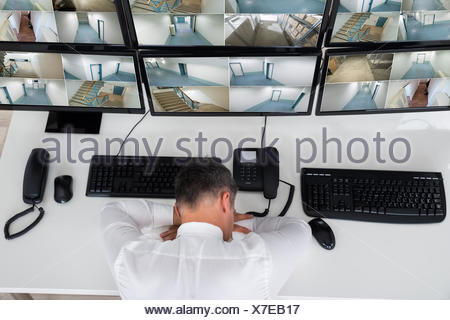 High angle view of operator sleeping while leaning on security Stock ...