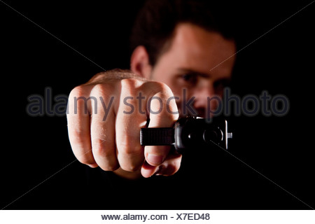 Man holds hand gun pointed at viewer - model rellease available Stock ...