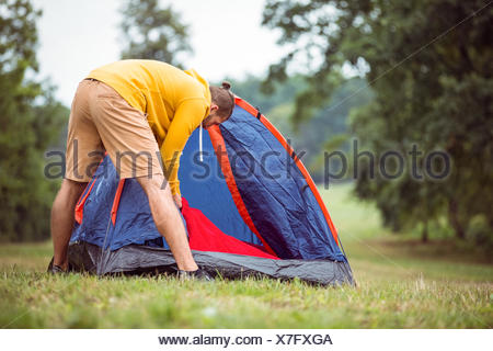 Man adventurer pitching tent camping gear outdoor Travel survival Stock ...