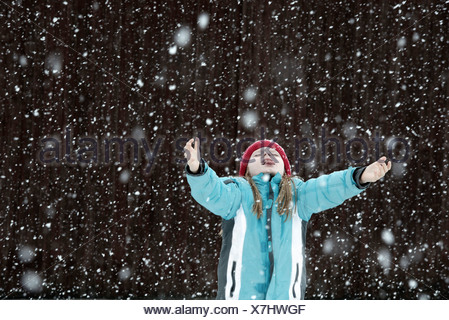 Girl trying to catch snowflakes Stock Photo - Alamy