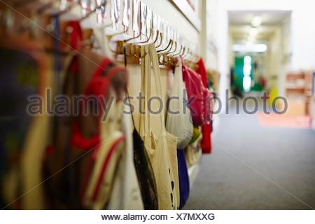 Bags hanging up on coat hooks in a secondary school cloakroom, UK Stock ...
