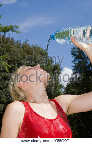 Germany, Berlin, Woman pouring water over face, portrait Stock Photo ...