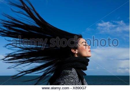A woman with her hair blowing in the wind across her face Bad Hair Day ...