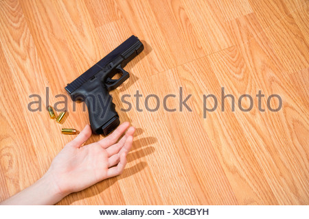 Woman lying on floor with gun Stock Photo: 21939643 - Alamy