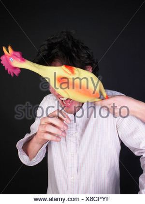 man getting hit with rubber chicken Stock Photo - Alamy