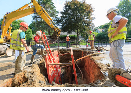 Construction worker entering shoring to inspect water main Stock Photo ...