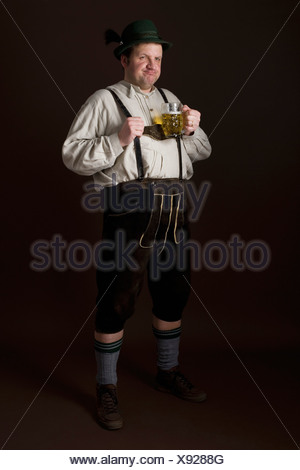 Stereotypical German man in Bavarian costume drinking a beer and Stock ...