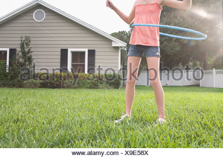 Girl hula hooping in backyard Stock Photo - Alamy