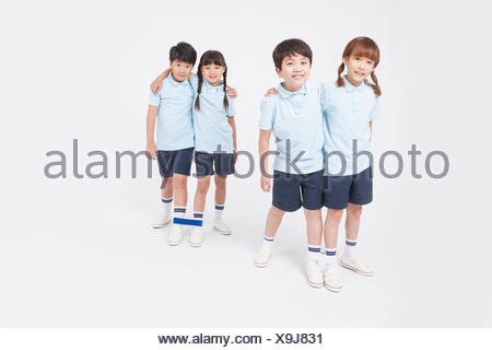 Two pairs of elementary school students with their feet tied together ...