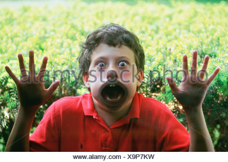 Young boy pressing his face against glass window Stock Photo - Alamy