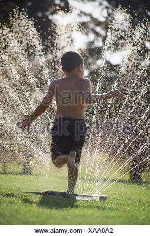 Boy running through sprinklers Stock Photo: 20245546 - Alamy
