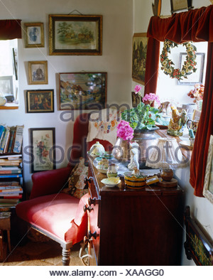 Pictures on wall in cluttered Victorian style early nineties living ...