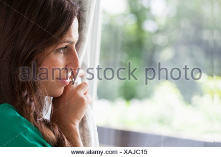 Woman peeking out window Stock Photo: 19113844 - Alamy