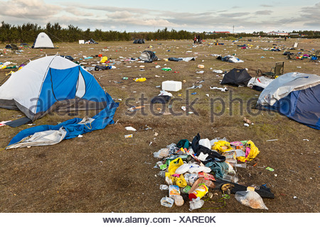 Meadow full of garbage, waste, destroyed tents and broken camping ...