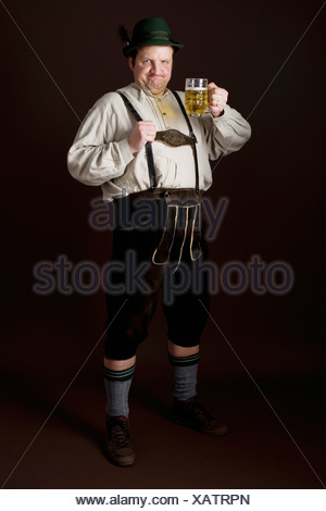 Stereotypical German man in Bavarian costume drinking a beer and Stock ...