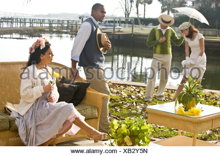 Portrait of 1920s socialite men relaxing at garden party on water's ...