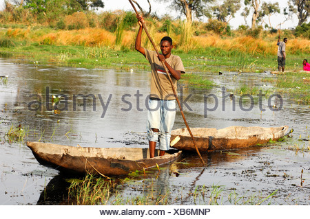 Botswana people Bayei mokoro poler at sunset in the Okovango Delta ...