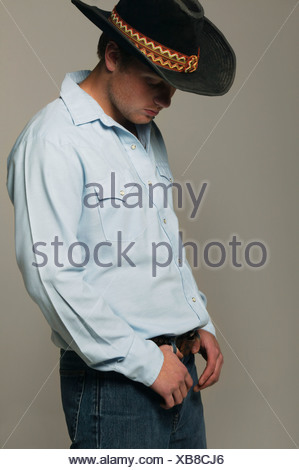 Cowboy looking down with thumbs in belt loops Stock Photo - Alamy
