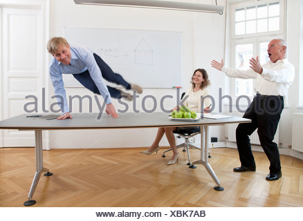 Businessman jumping over a hurdle Stock Photo - Alamy