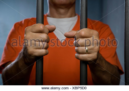 A prisoner standing behind prison bars Stock Photo: 20027624 - Alamy