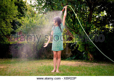 Girl holding water hose Stock Photo - Alamy