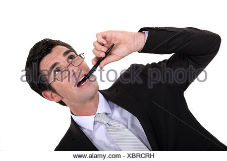 Businessman chewing his pen Stock Photo: 73123867 - Alamy