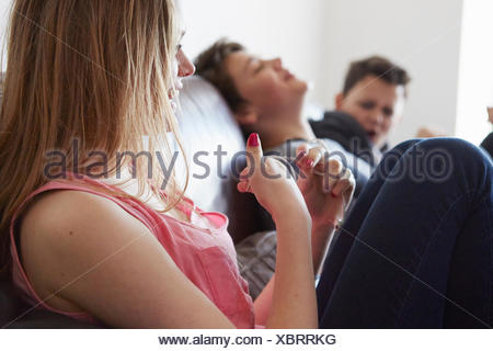 Girl fiddling with earphones on sofa Stock Photo: 86281476 - Alamy