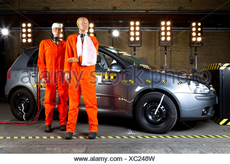 Two crash test dummies with bandages standing by a crash test car Stock ...