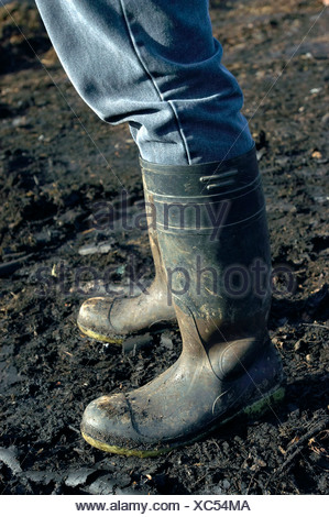 Muddy dirty 'wellies' wellington boots of a person sitting in a Stock ...