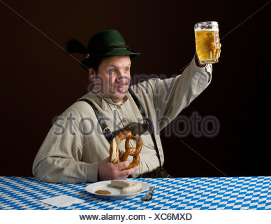Stereotypical German man holding a beer and a pretzel Stock Photo ...