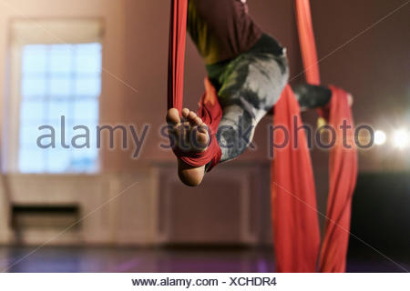 Young girl acrobat. Practicing aerial silks. Strong woman doing stunts ...