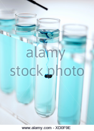Science chemical research pipette dropping sample liquid into test tube ...
