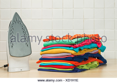 Piles of clean laundry and iron Stock Photo - Alamy