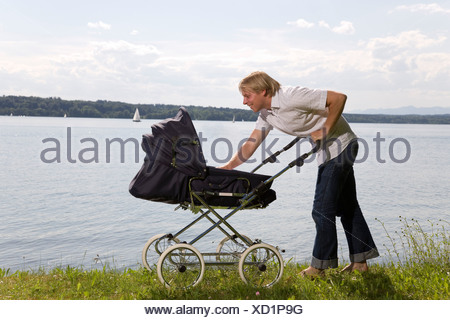 Man pushing a baby stroller Stock Photo - Alamy