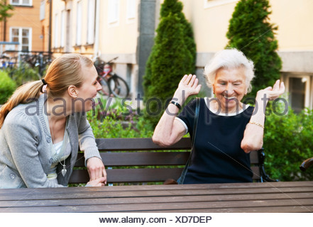 Women talking bench, two elderly women chat on a park bench in the ...