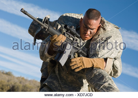US Army soldier carrying wounded friend Stock Photo - Alamy