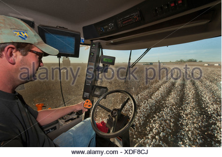 FARMER INSIDE COMBINE CAB USING GPS AND OTHER TECHNOLOGY TO FARM Stock ...