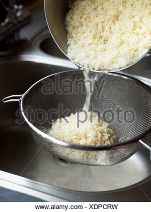 Draining cooked rice in sieve Stock Photo: 71810769 - Alamy