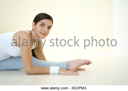 A young woman doing the splits while working out doing floor Stock ...