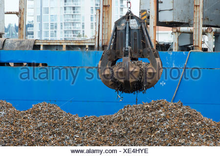 Crane loading scrap metal onto cargo ship, Newhaven, Sussex, UK Stock ...
