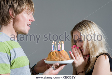 Woman giving a plate of cake to a man in front of a refrigerator Stock ...