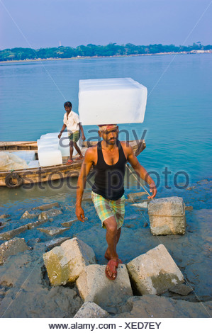 Man carrying a large block of ice on his head, Barisal, Bangladesh ...